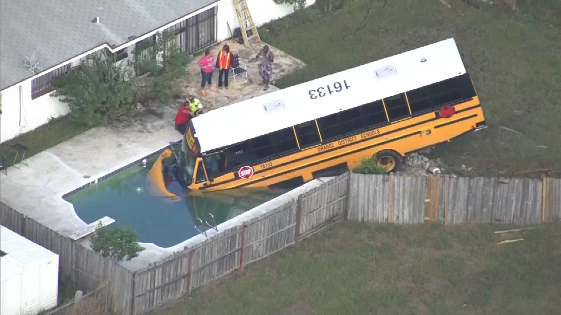 School bus crashes into swimming pool